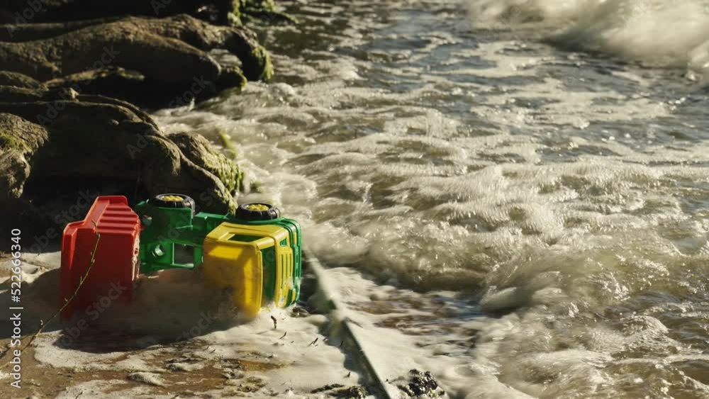 Element and ecology concept. A toy truck is washed by the waves of the ...