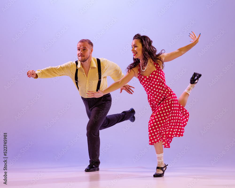 Active and emotional couple in colorful retro style costumes dancing ...