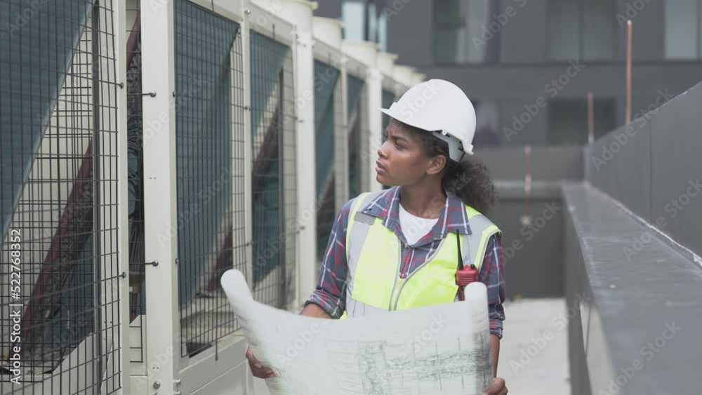African female civil engineer inspects a commercial building ...