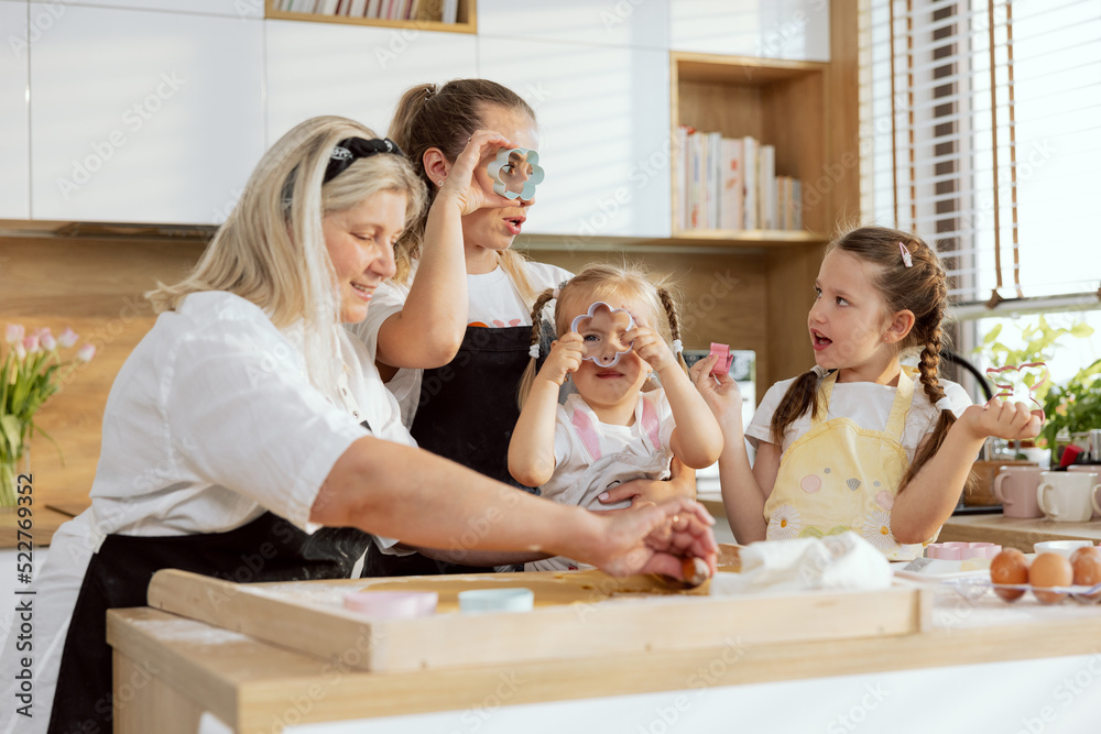 Young mother holding preschooler daughter holding cookie cutters as ...