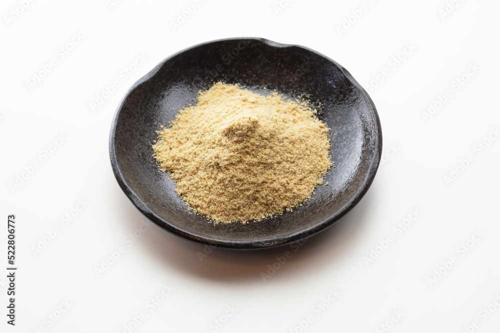 Nuka powder. Mound or heap of Nuka on a black plate, used in making ...