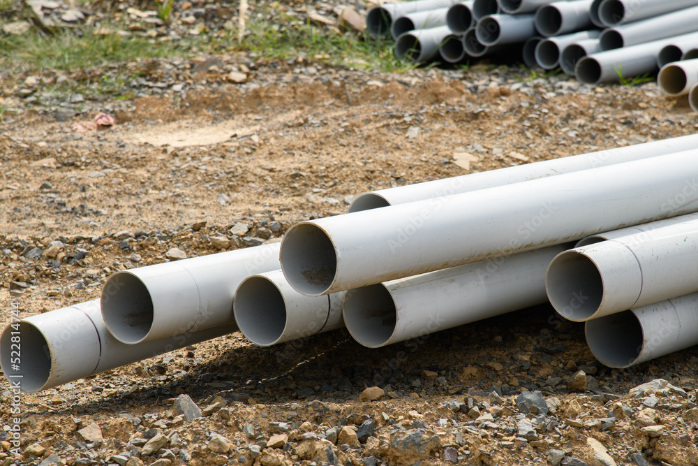 Sewer pipes waiting to be placed into the ditch at construction site ...