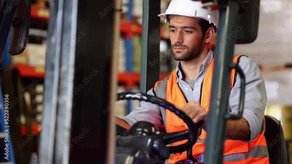 Warehouse staff driving forklift operator moving boxes in industrial ...