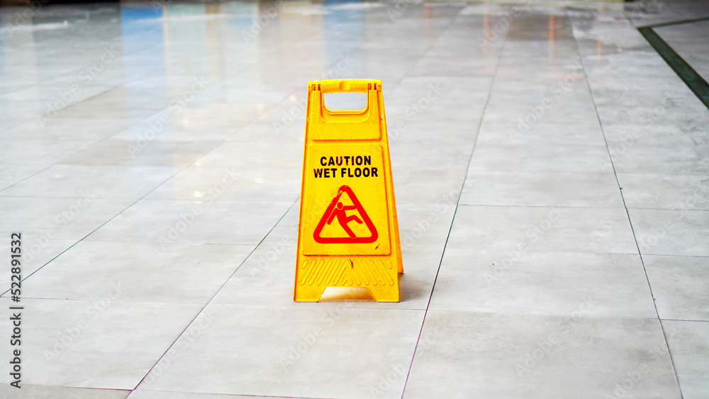 Caution wet floor sign. Wet floor caution sign on walkway near the ...