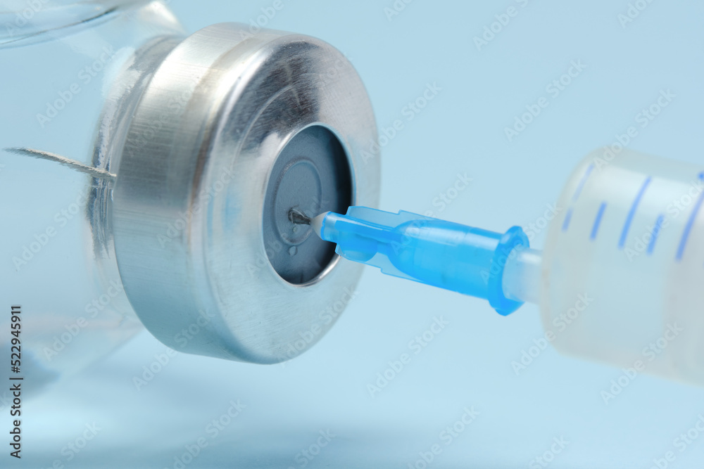 Taking medication into a syringe for injection. Closeup macro. Blue ...