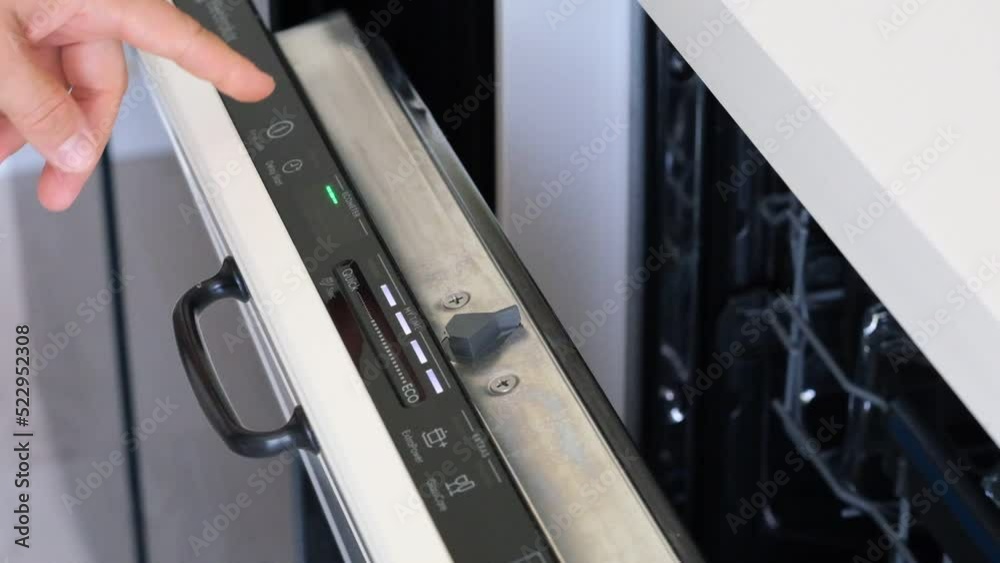 Vidéo Stock A finger is turning on a built-in dishwasher and selecting ...