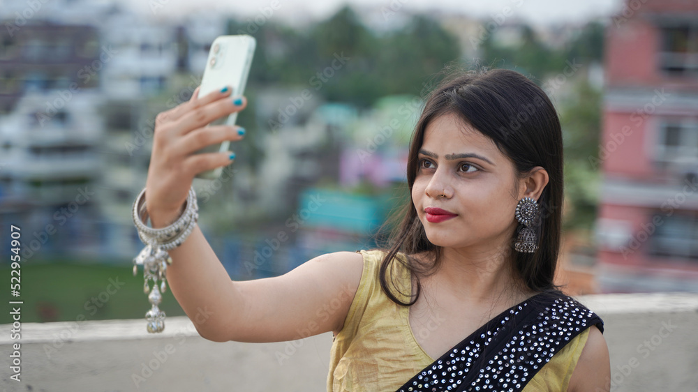Beautiful Indian girl taking selfie on her mobile phone outdoor ...