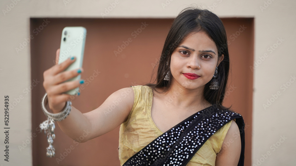 Beautiful Indian girl taking selfie on her mobile phone outdoor ...