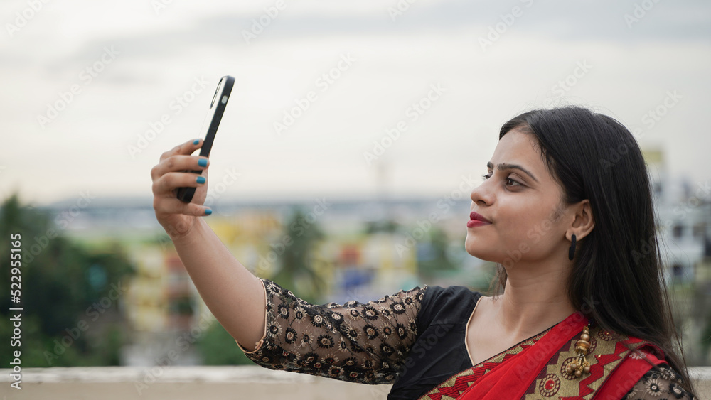 Beautiful Indian girl taking selfie on her mobile phone outdoor ...