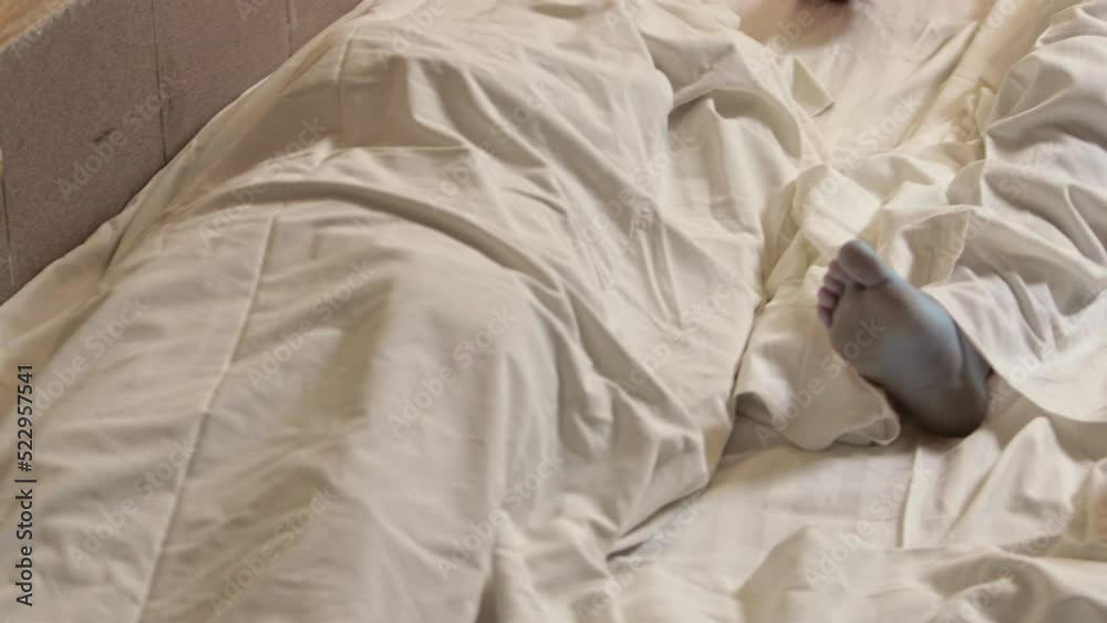 Human corpse covered with a sheet in morgue. Homo dead comprise with ...