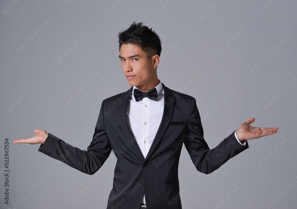 Handsome fashion model. elegant man wear formal black suit with bow tie ...