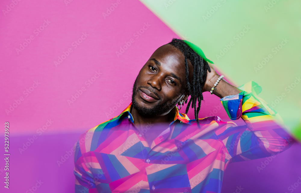 artistic portrait with gel lights. Handsome man posing on colored ...