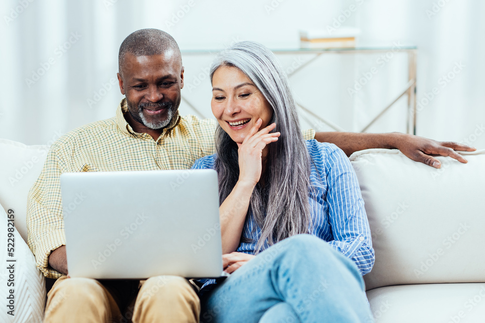 cinematic image of an happy multiethnic senior couple. Indoors ...