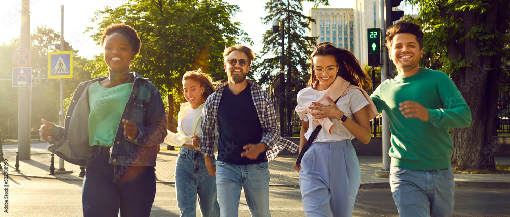 Urban street life. Cheerful group of multiracial friends walking around ...