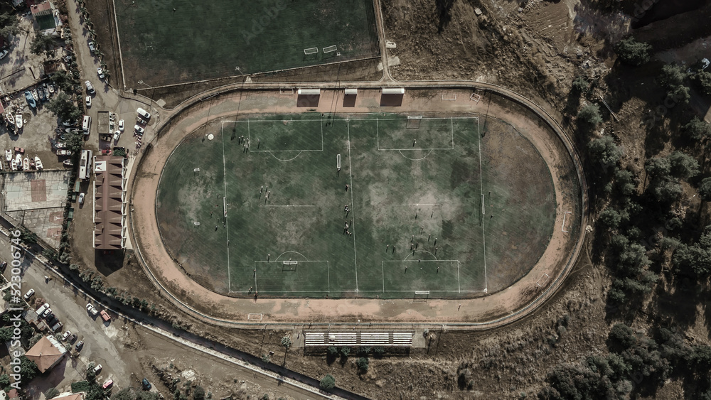 Old abandoned football stadium. Remains of a green lawn. Shabby ...
