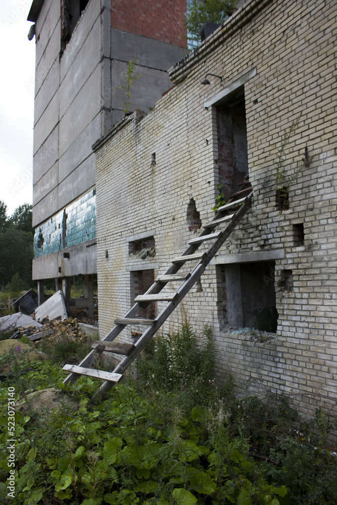 wooden staircase to the second floor of a destroyed industrial brick ...
