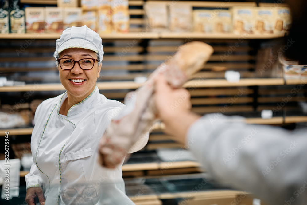 Happy female baker serving customer in bakery. Stock 写真 | Adobe Stock