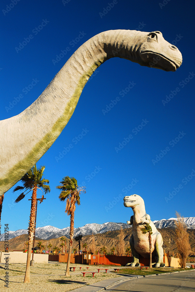 A large brontosaurus and T Rex stands at a roadside attraction in ...