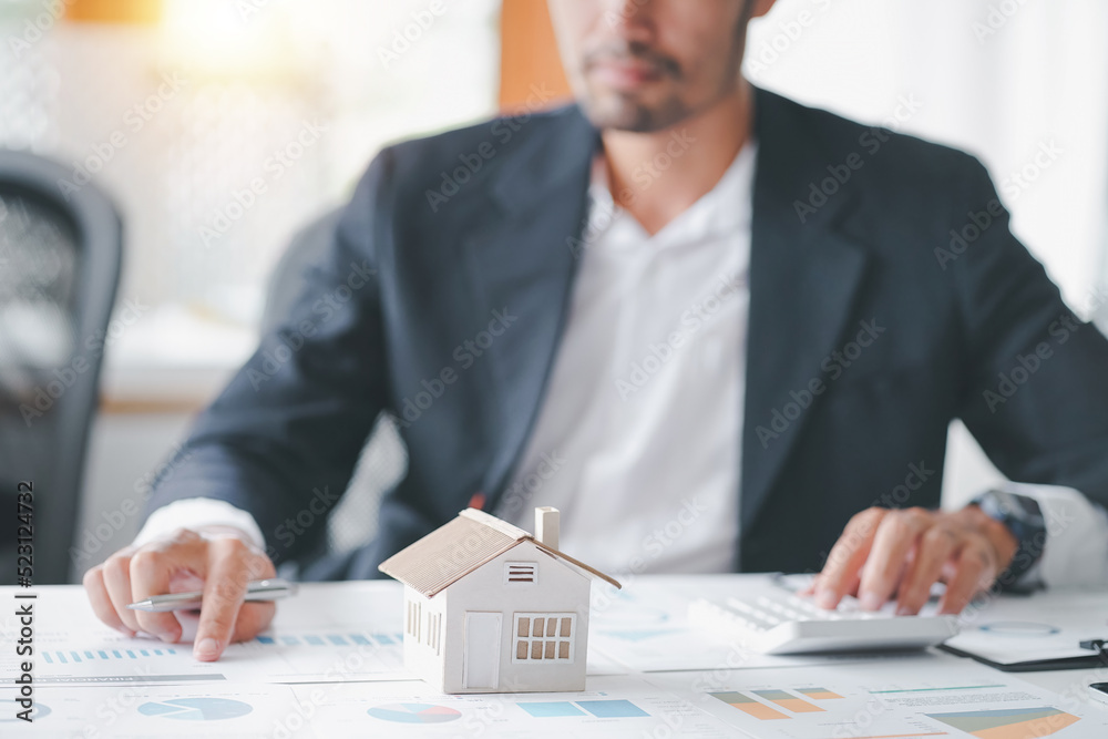 Cropped shot of estate agent using calculator calculate for contract to ...