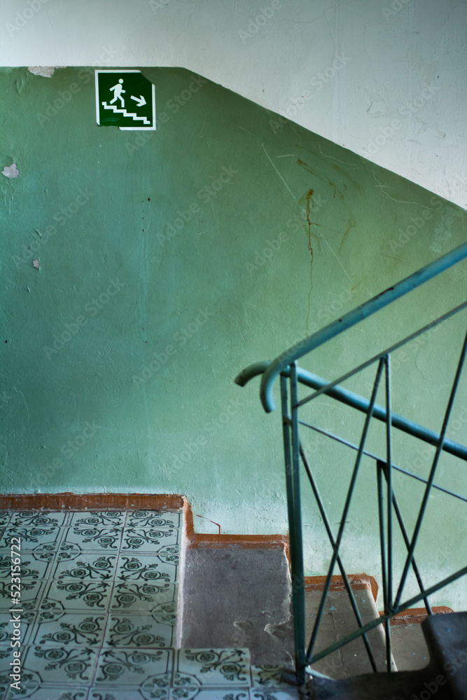 "Direction to downstairs emergency exit" sign on a green wall in an ...