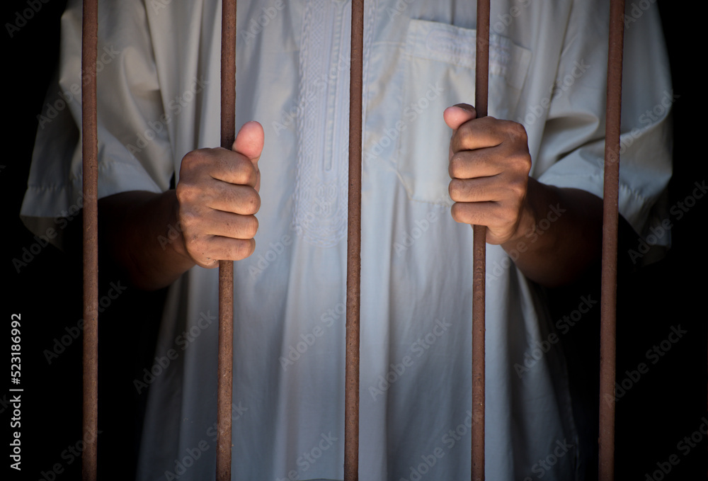 Religious muslim islam man in white session hold steel in jail on black ...