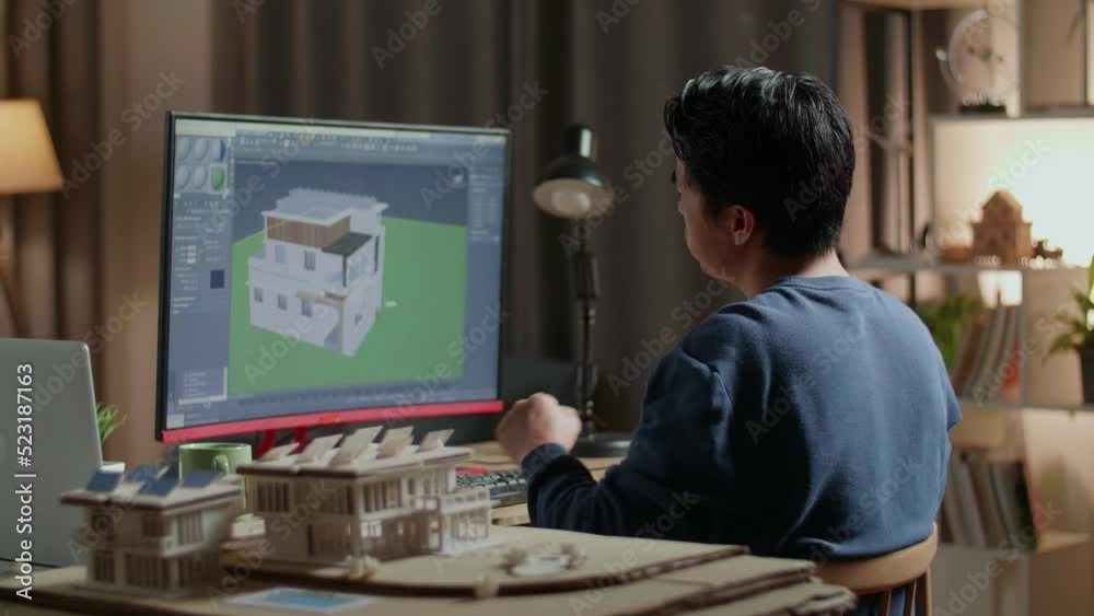Asian Male Engineer Stretching While Designing House On A Desktop At ...
