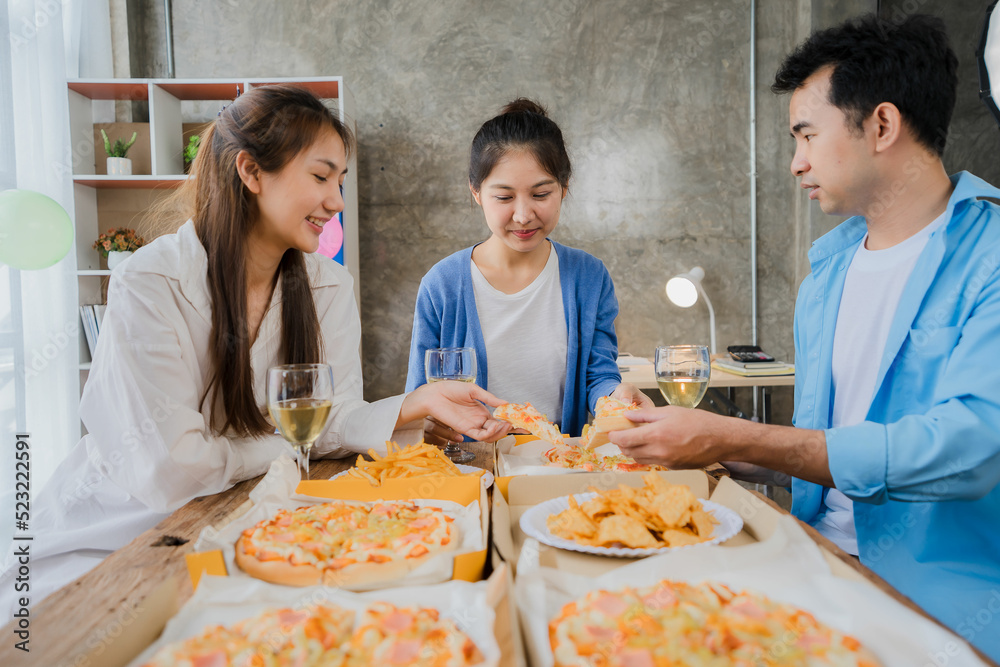 Young Asian male and female colleagues having lunch in the office ...