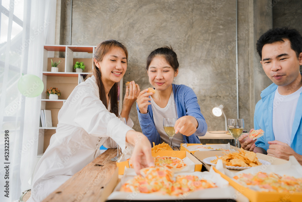 Young Asian male and female colleagues having lunch in the office ...