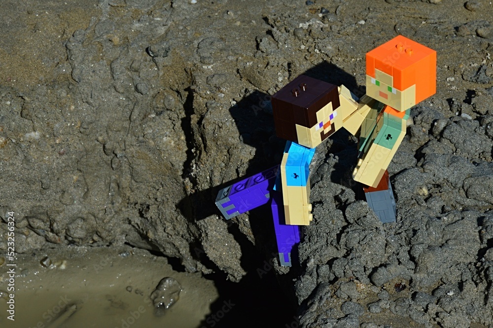 LEGO Minecraft figure of Alex is helping Steve from large black sand ...