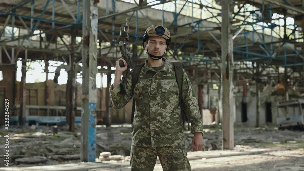 Portrait of strong and brave man posing on destroyed steel plant with ...