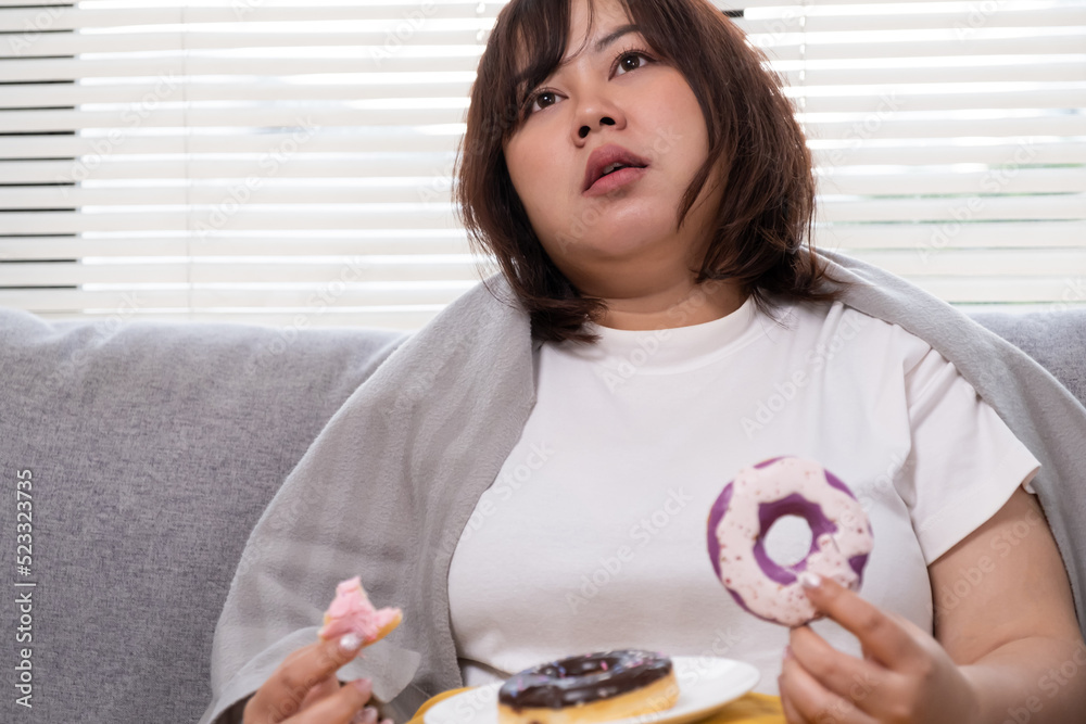 Young Asian oversize women gain weight while eating donut, bread and ...