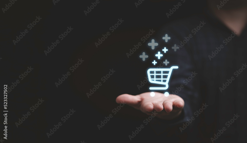 Businessman hand holding virtual trolley cart icons with plus sign ...