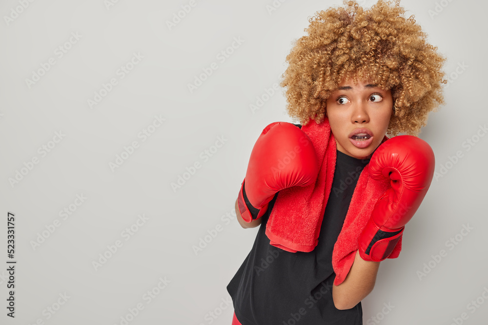 Foto de Scared woman boxer wears black t shirt boxing gloves red towel ...