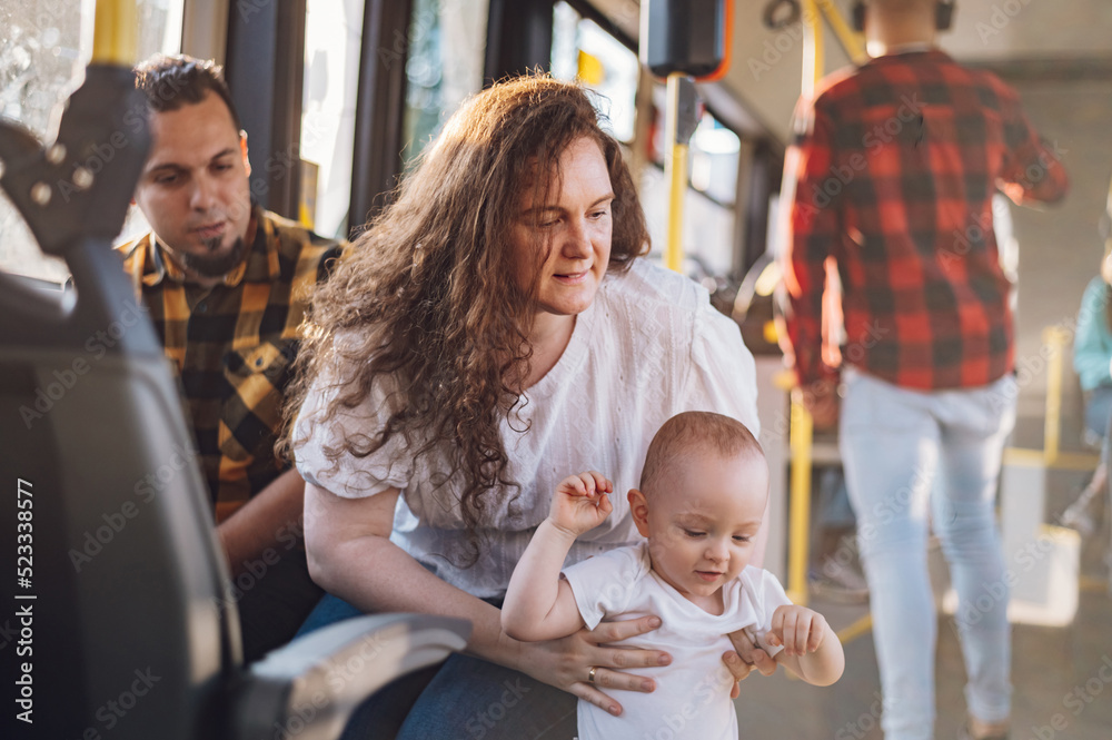 Parents riding a bus with their child during a day. Stock Photo | Adobe ...