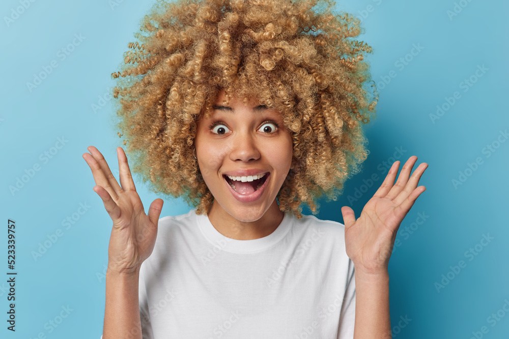 Human reactions and facial expressions concept. Excited cheerful woman feels surprised keeps ...