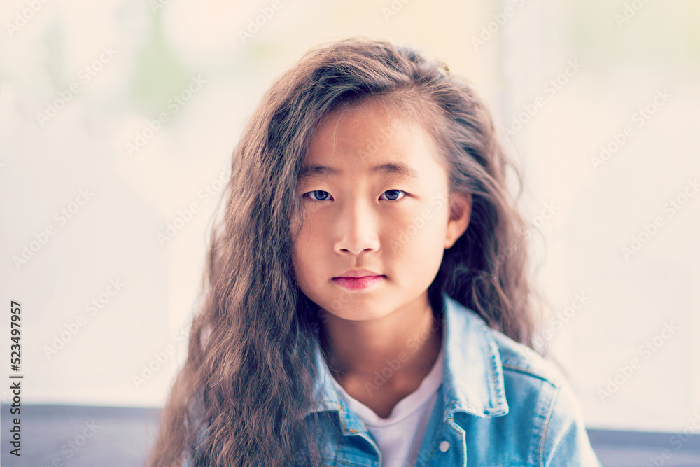 Asian curly brunette girl child with long hair in a denim shirt Stock ...