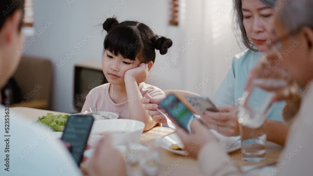 Asian family using phone while eating food not attention to girl kid ...