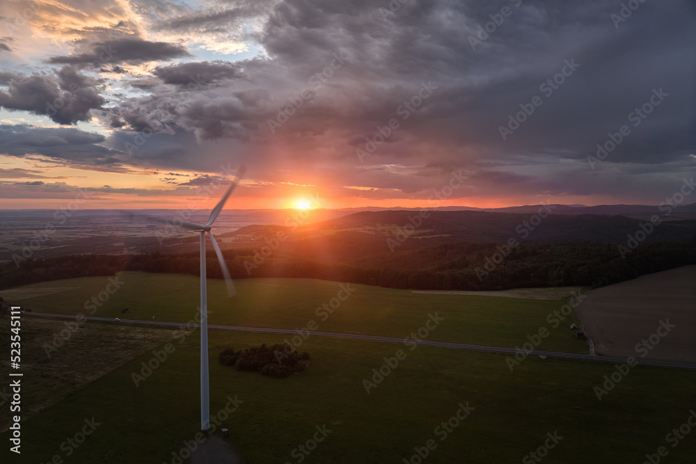 Aerial view of wind power plant in full load, illuminated with dramatic ...