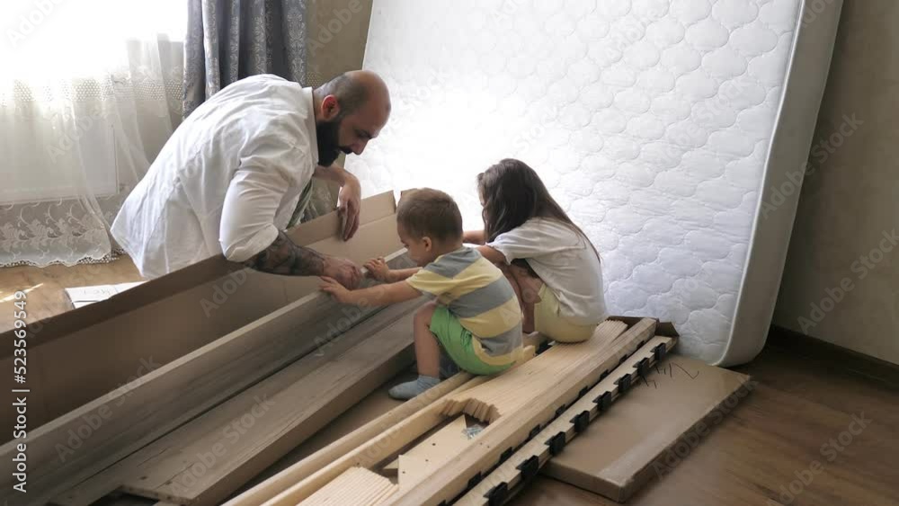 Dad, daughter and son open the boxes for the future bed in the kids ...