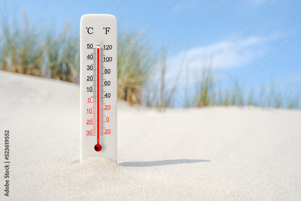 Hot summer day. Celsius and fahrenheit scale thermometer in the sand ...