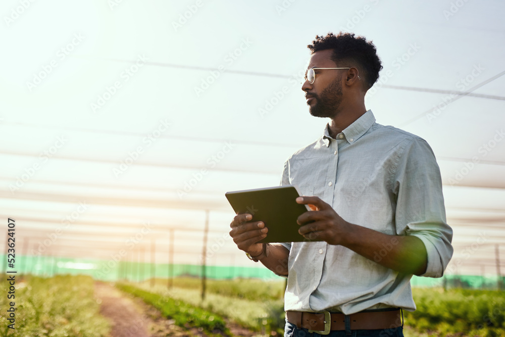 Thinking farmer with digital tablet checking sustainable farming growth ...