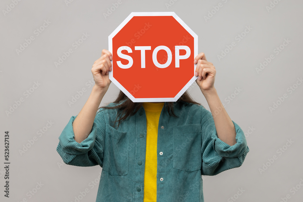 Attention, prohibited way. Unknown person hiding face behind Stop ...