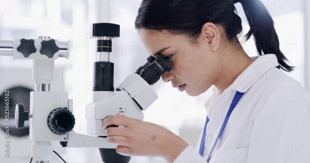 Medical science intern using a microscope for a futuristic, innovative ...