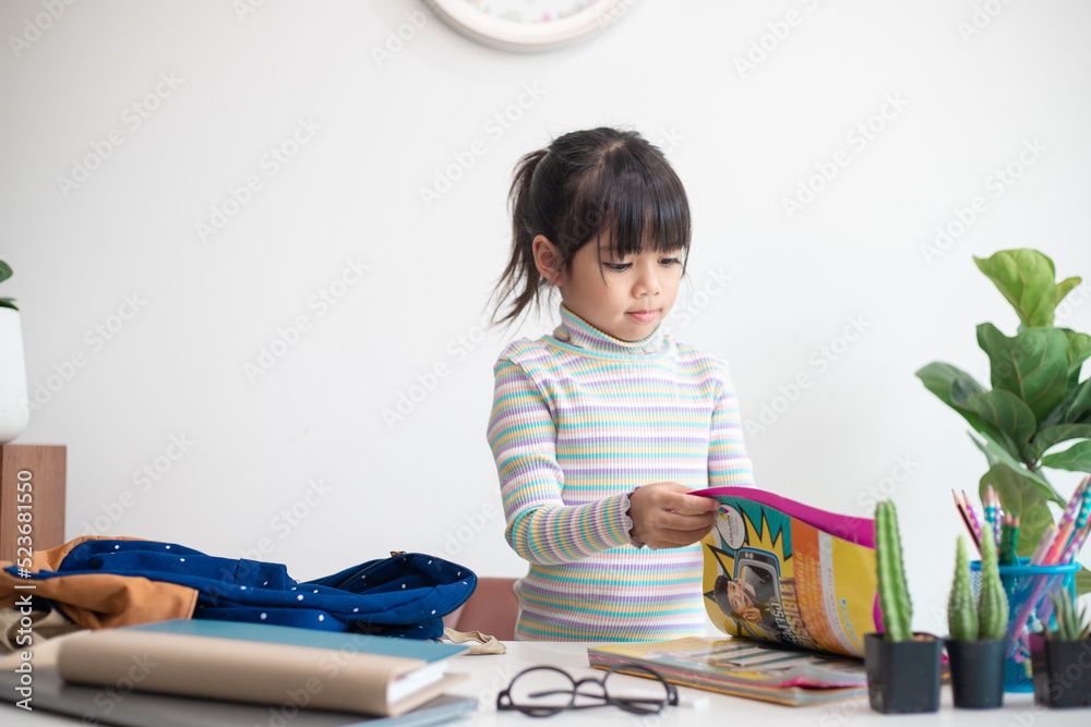Asian cute primary school girls packing their school bags, preparing ...