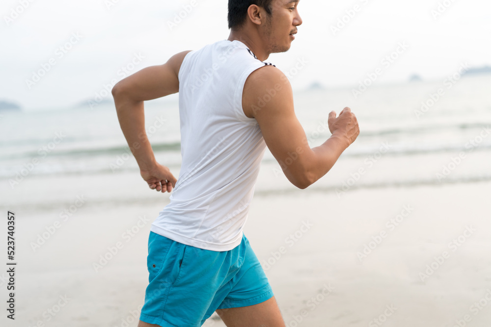 asian sport man running along seaside. running on beach with healthy ...