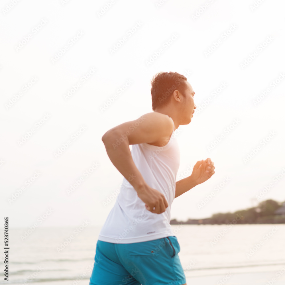 asian sport man running along seaside. running on beach with healthy ...