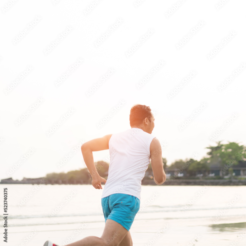 asian sport man running along seaside. running on beach with healthy ...