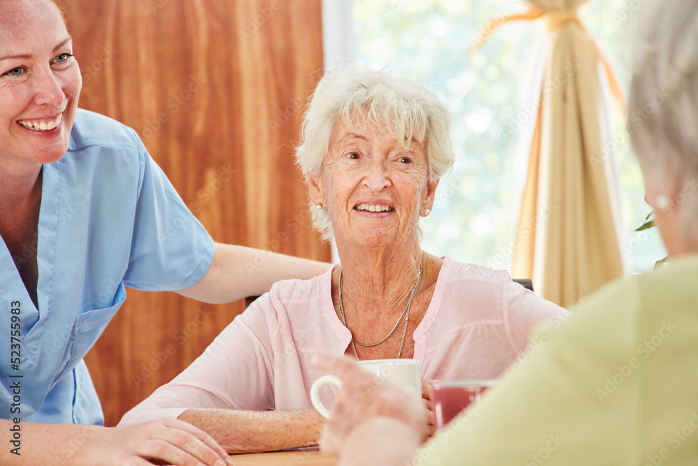 Seniors and smiling caregiver talking Stock Photo | Adobe Stock