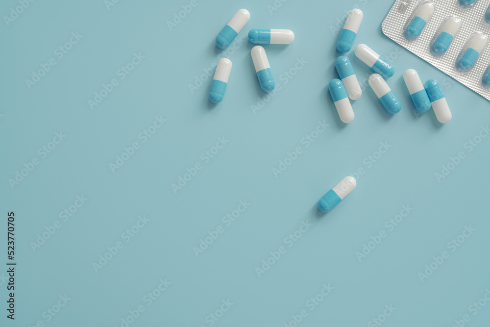Antibiotic capsule pills on blue background. Prescription drugs. Blue ...