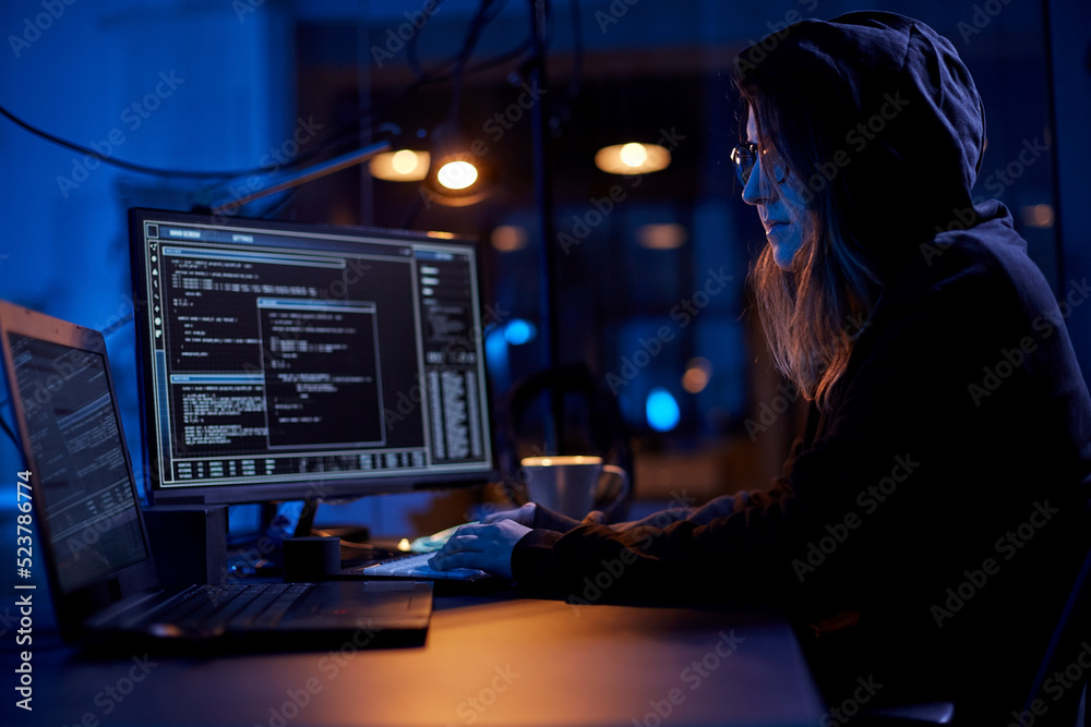 cybercrime, hacking and technology concept - female hacker in dark room ...